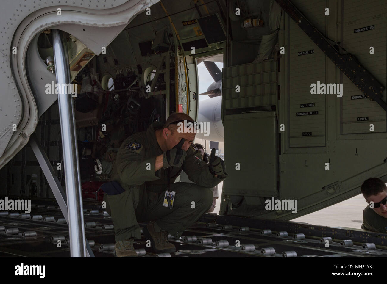 A U.S. Air Force loadmaster from the 71st Rescue Squadron guides a ...