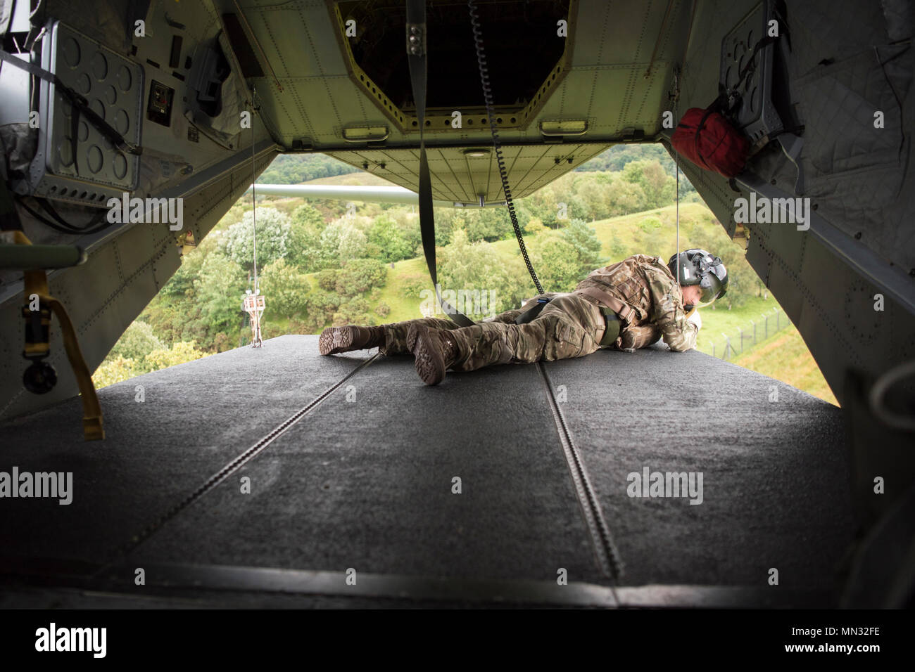 A Royal Marine Aircrewnan looks out the side of a Merlin Mk2 Helicopter ...