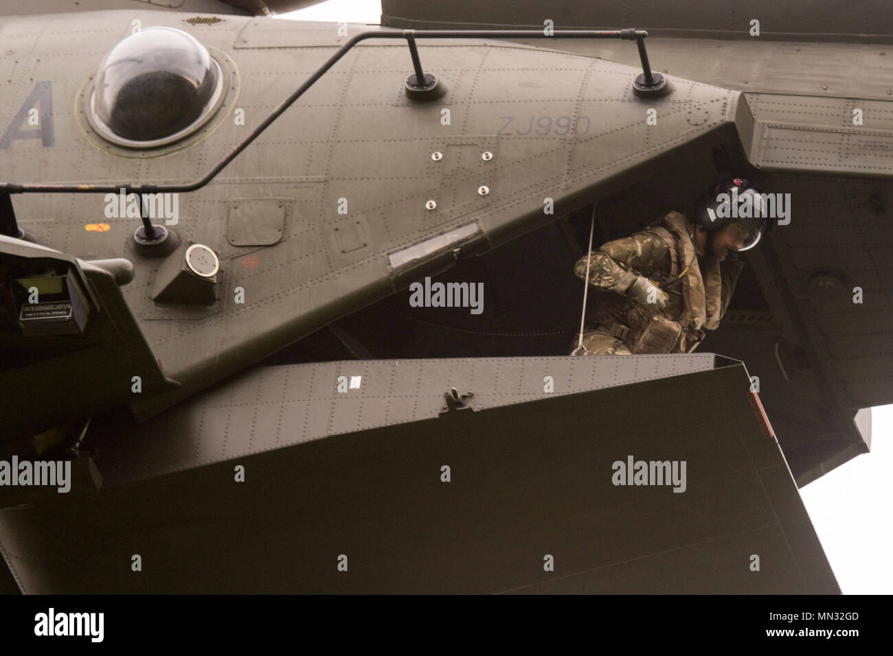 A Royal Marine Aircrewnan looks out the side of a Merlin Mk2 Helicopter ...