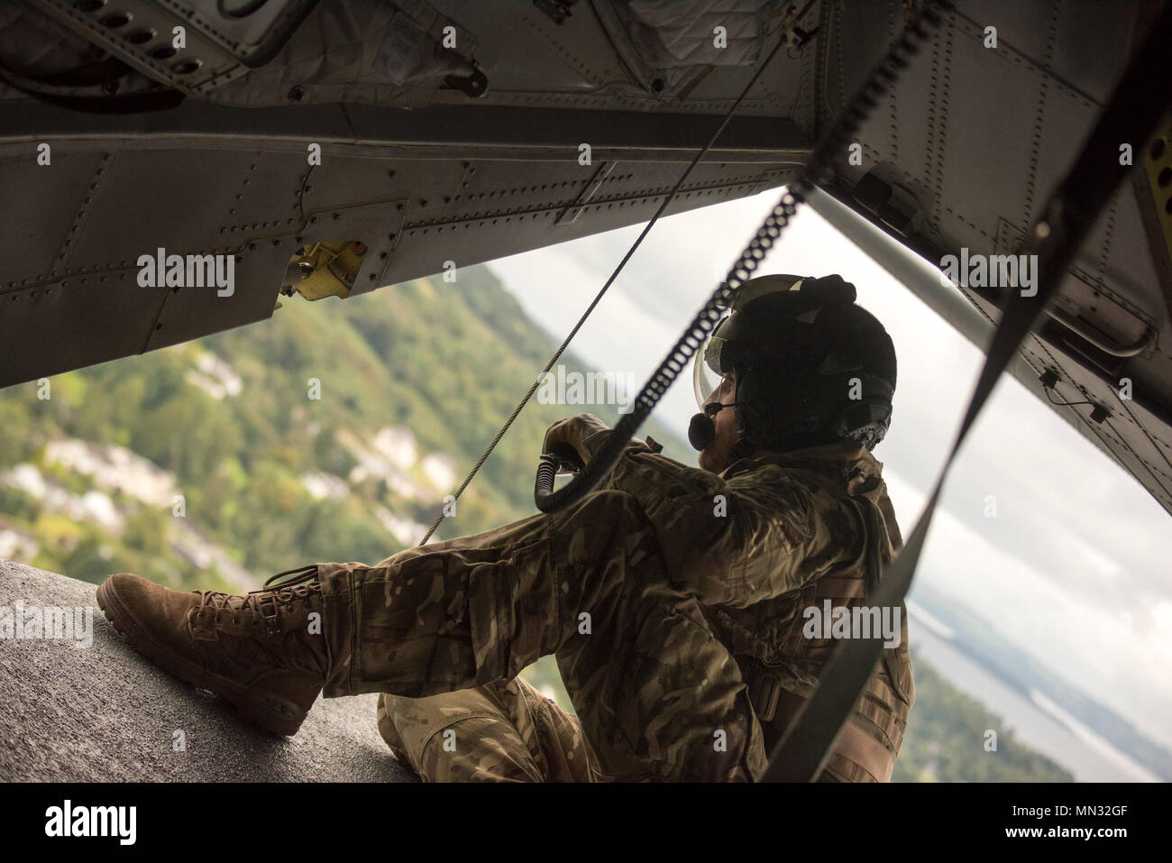 A Royal Marine Aircrewnan looks out the side of a Merlin Mk2 Helicopter ...