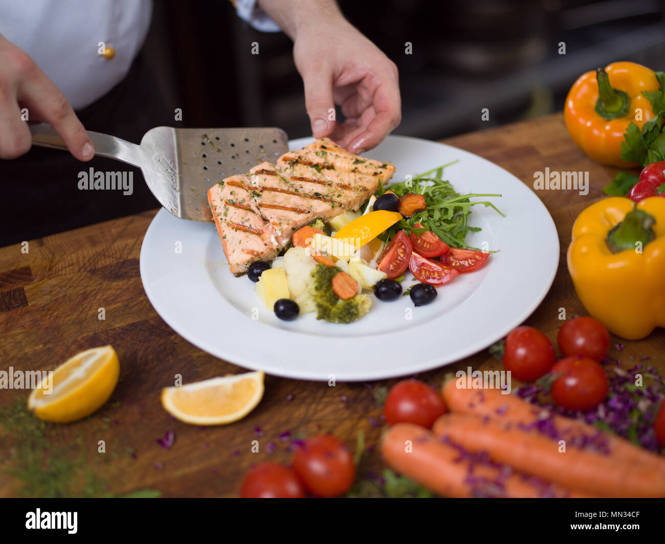 cook chef decorating garnishing prepared meal dish on the plate in ...