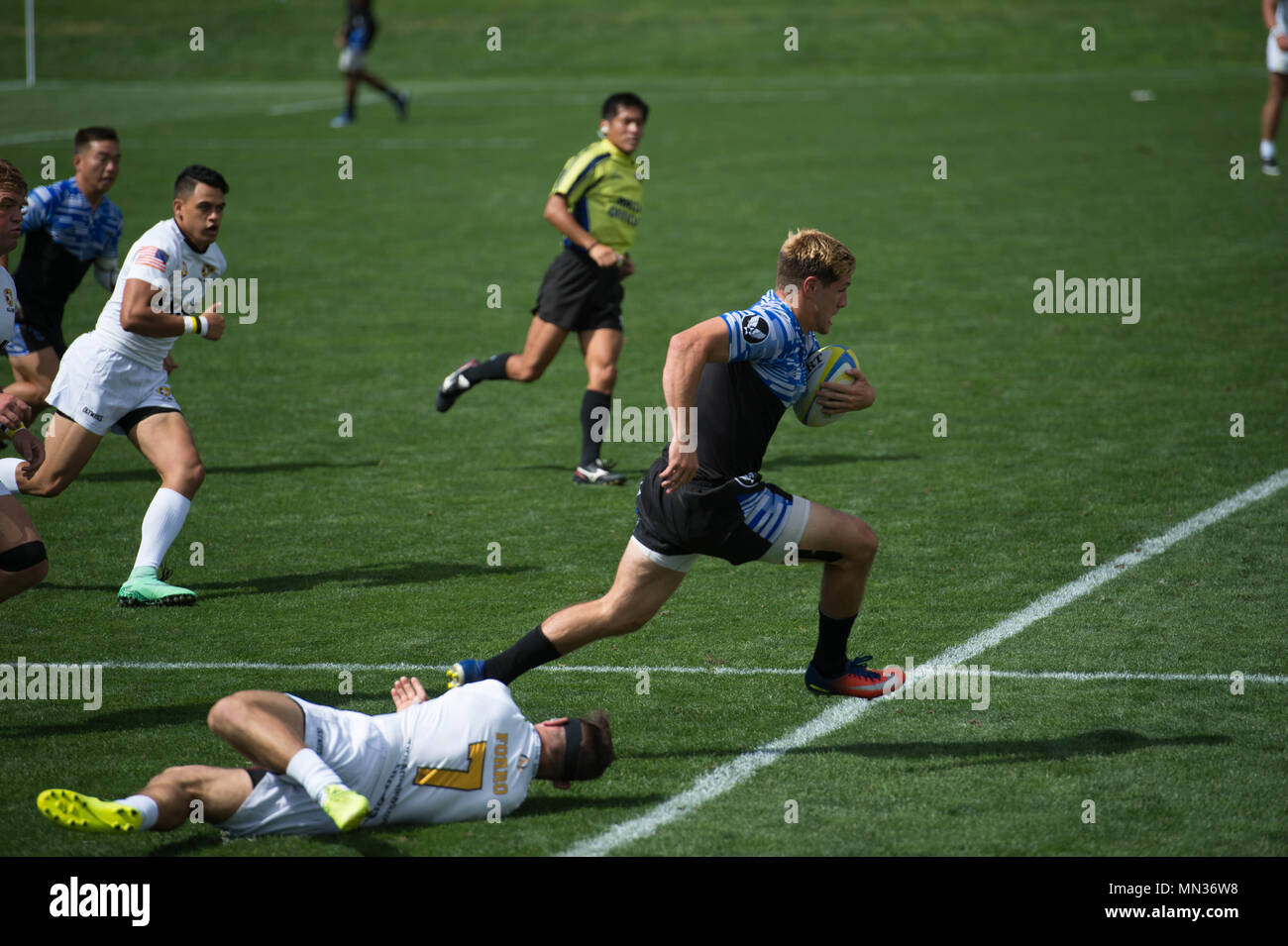 A member of the Air Force Rugby Team evades a tackle from team Coast ...