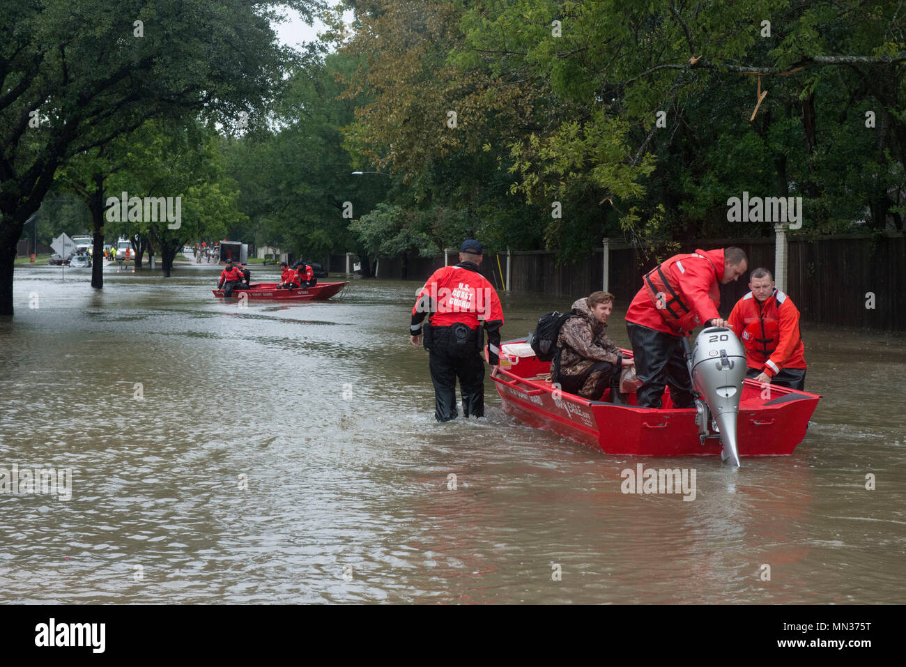 A Coast Guard Flood Punt Team transports a man across a flooded ...