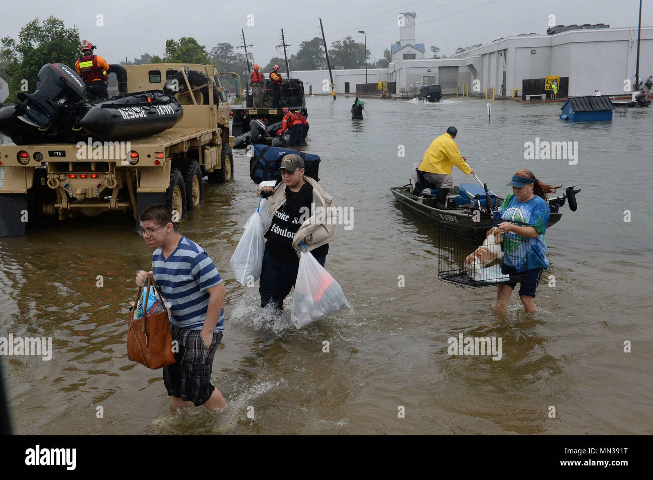 Flood victims evacuate their neighborhood assisted by Texas National ...