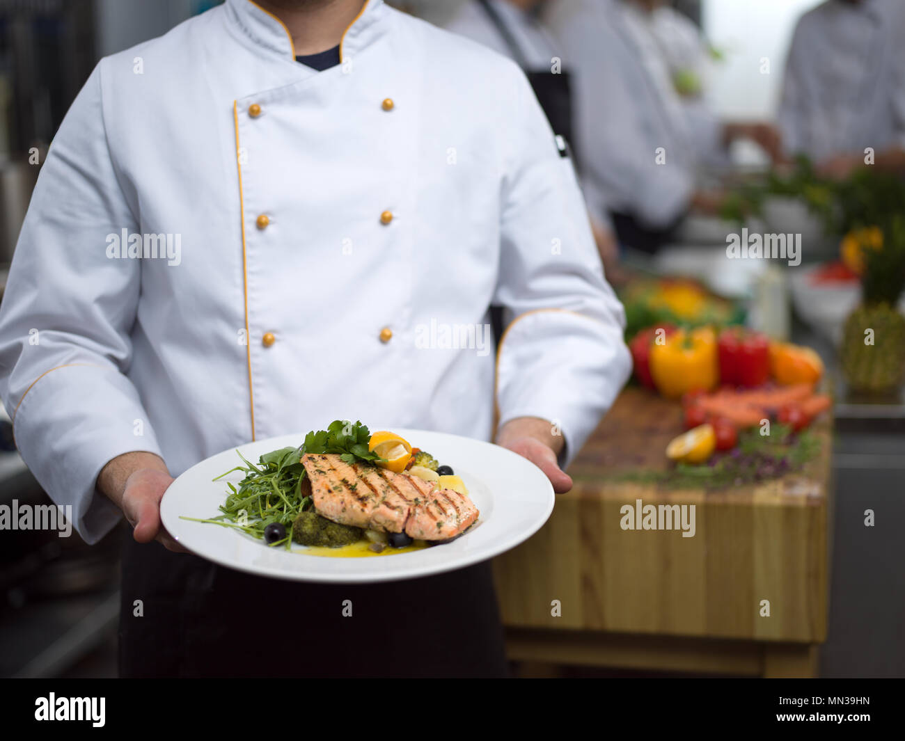 Chef holding fried Salmon fish fillet with vegetables for dinner in a ...