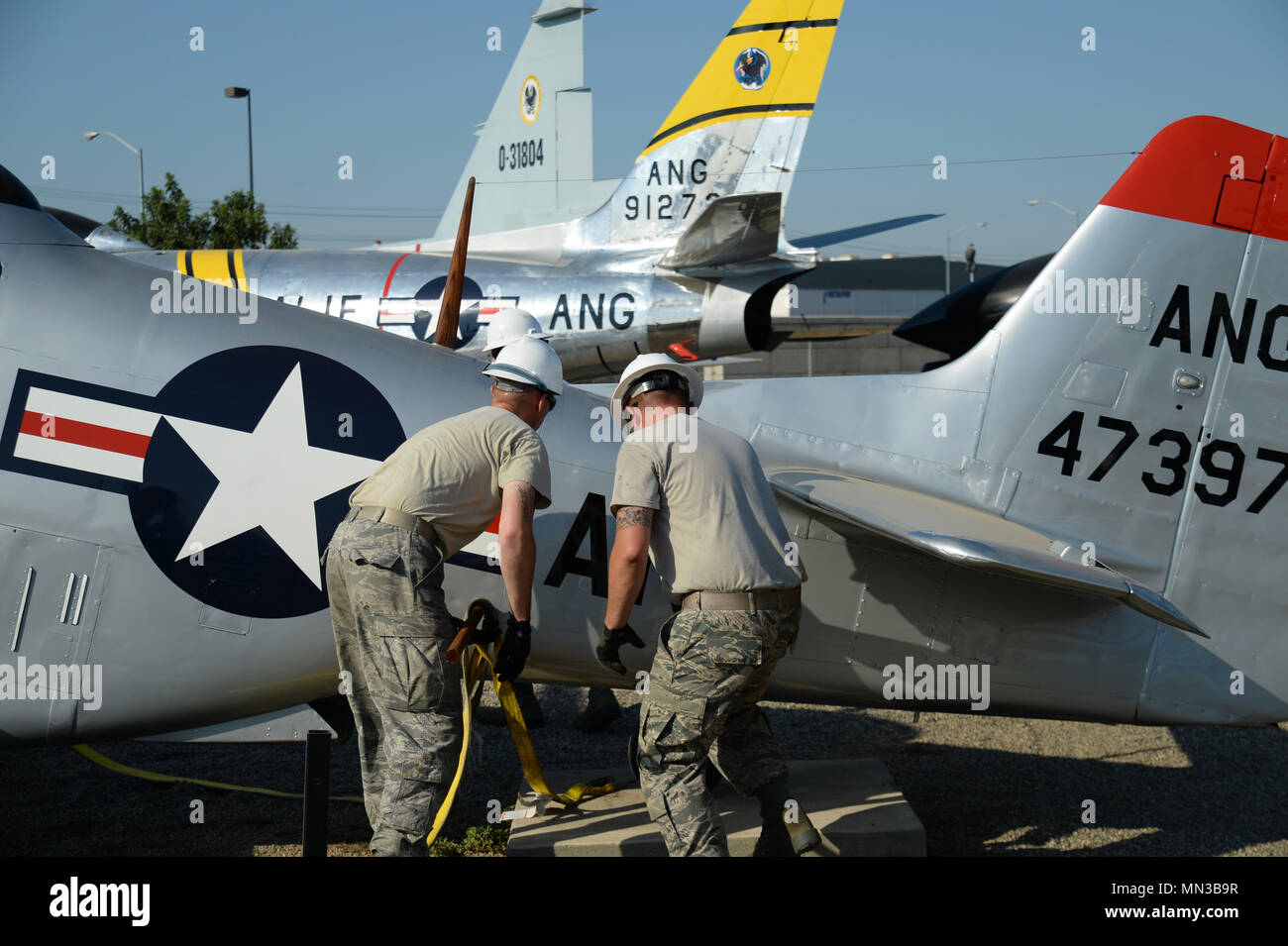 Airmen assigned to the 144th Maintenance Squadron, secure straps around ...