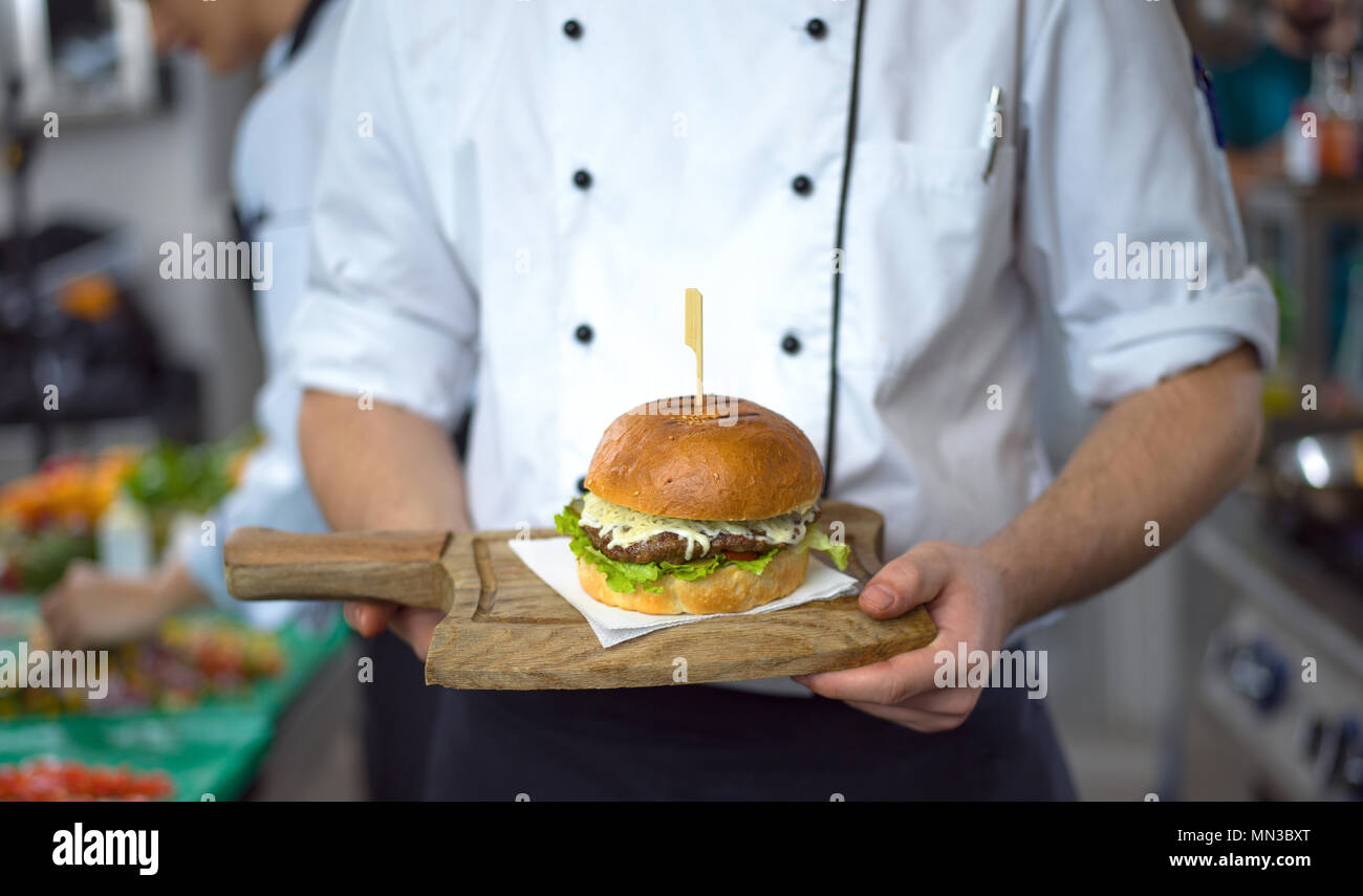master chef putting toothpick on a burger in restaurant kitchen Stock ...