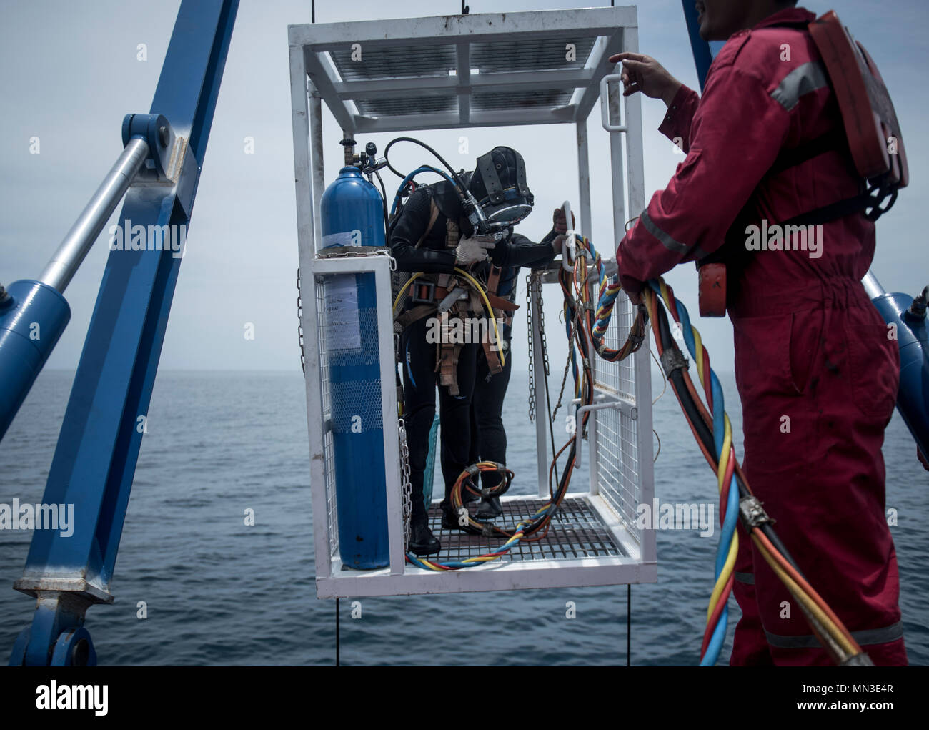Divers with Lam Hong Diving are lowered into the sea while supporting the Defense POW/MIA ...