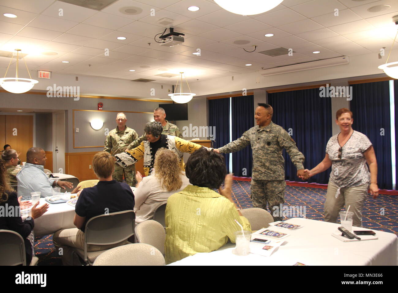Guest speaker Hester J. Moore requests community members join her in a ...
