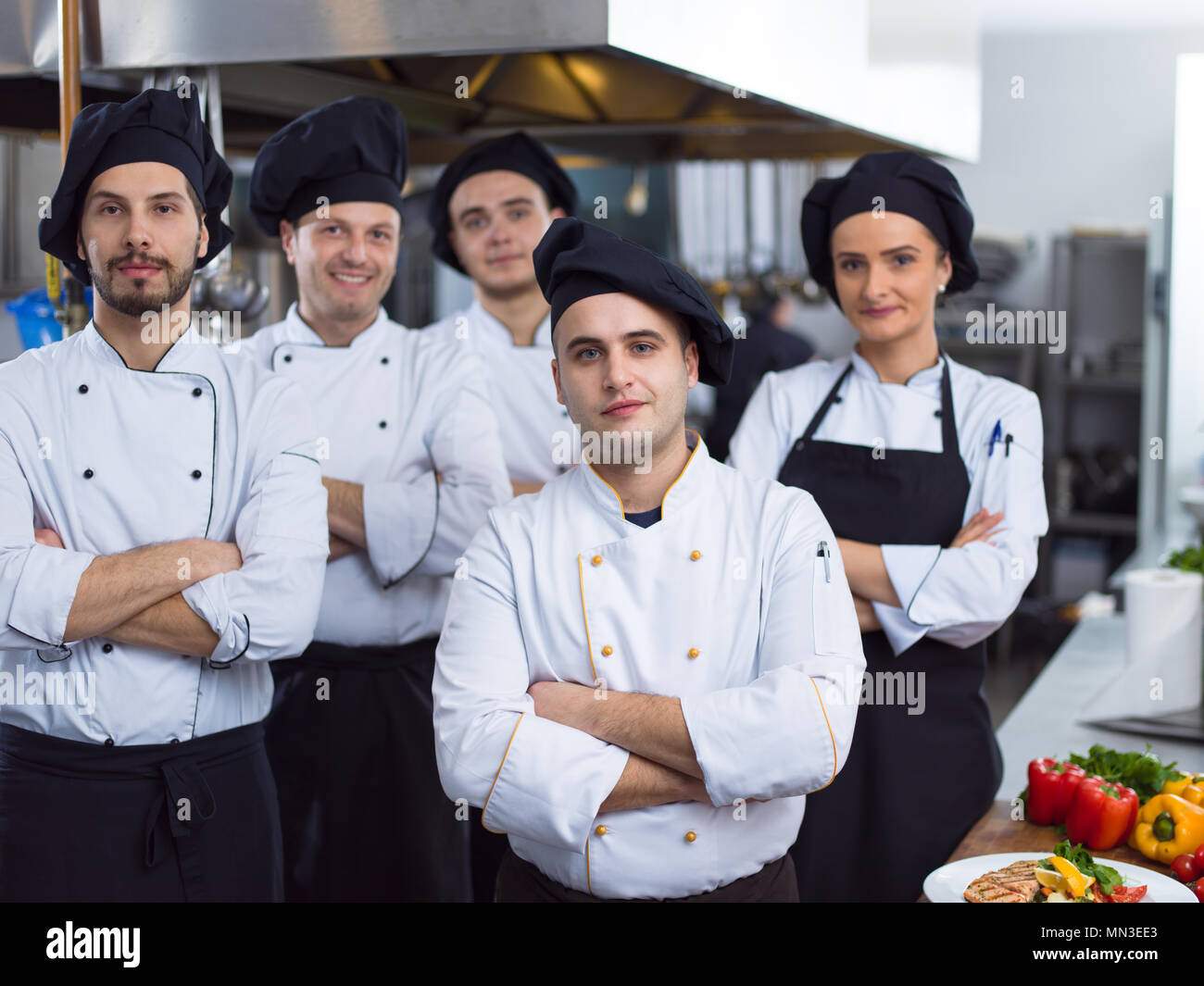 Portrait of group chefs standing together in commercial kitchen at ...