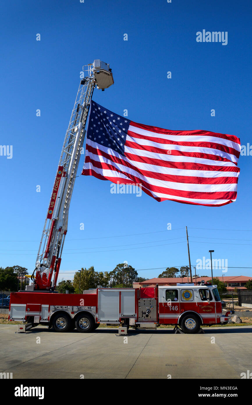An American flag is attached to the ladder of a fire engine at Travis ...
