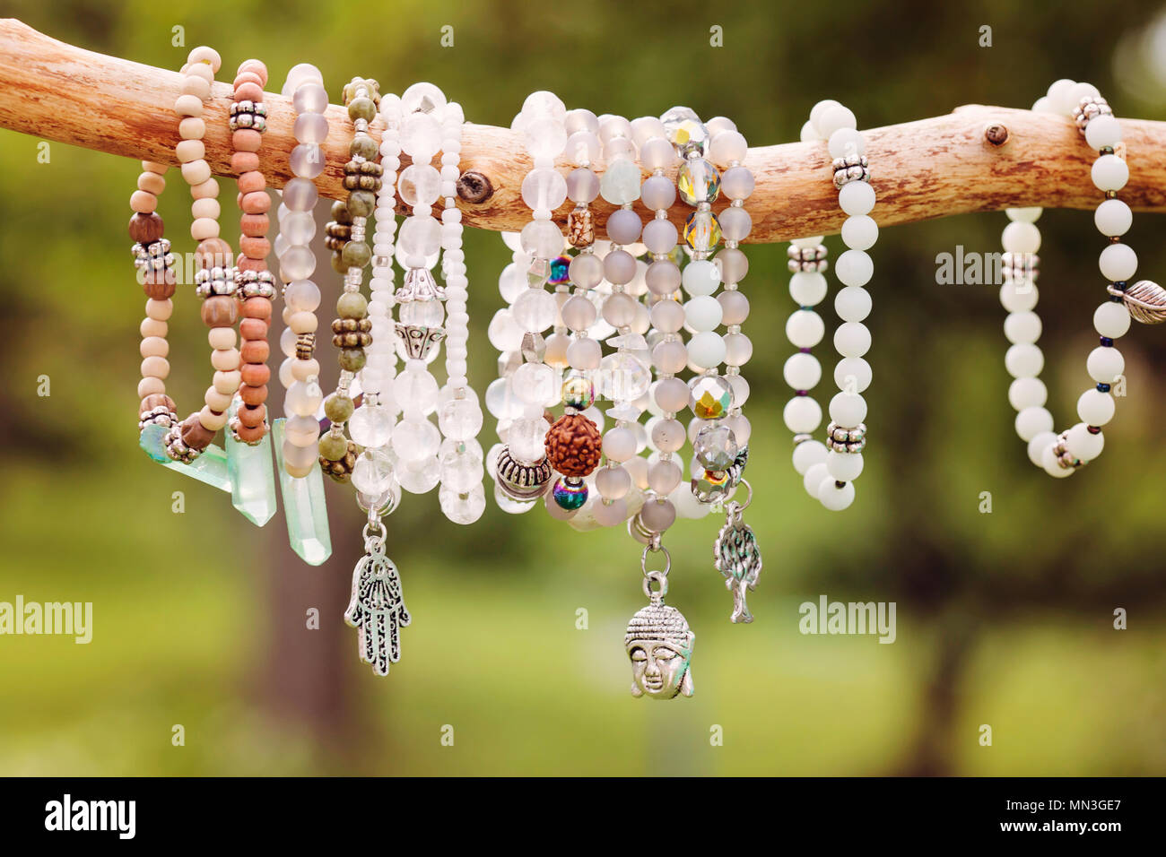 Natural bead bracelets hanging on natural branch Stock Photo - Alamy