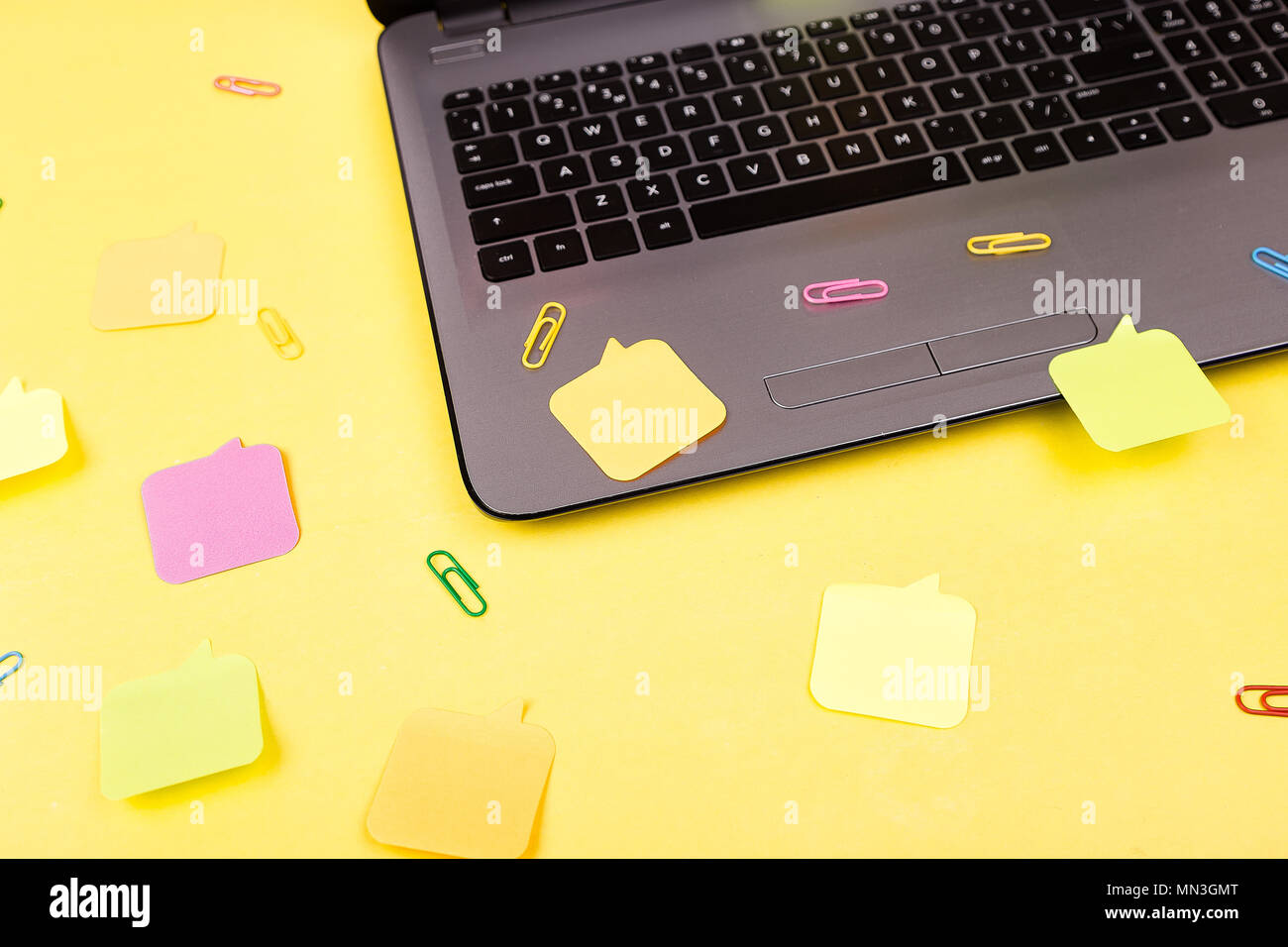Notebook with colorful stickers on yellow paper background. Workplace ...