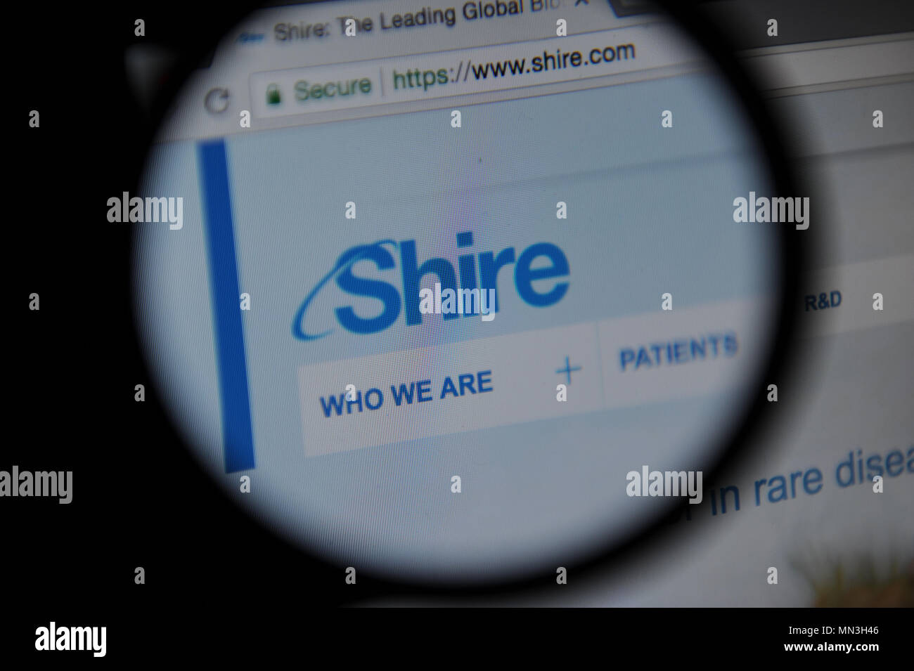Shire Pharmaceutical company website seen through a magnifying glass ...