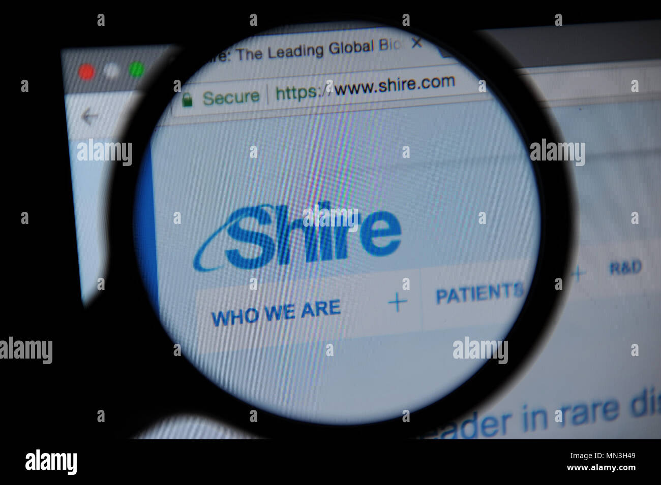 Shire Pharmaceutical company website seen through a magnifying glass ...