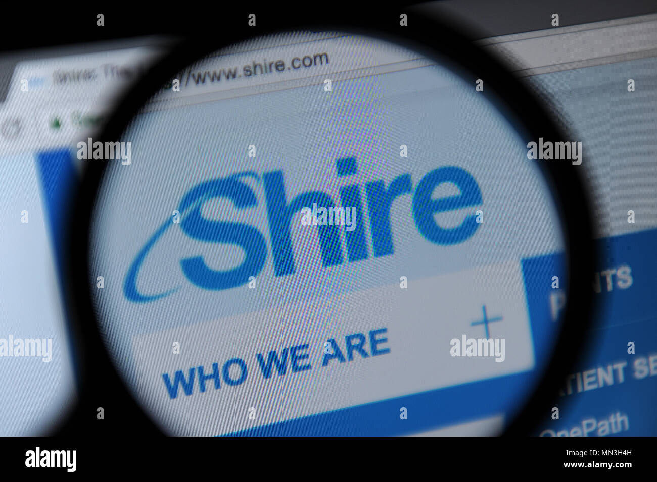 Shire Pharmaceutical company website seen through a magnifying glass ...