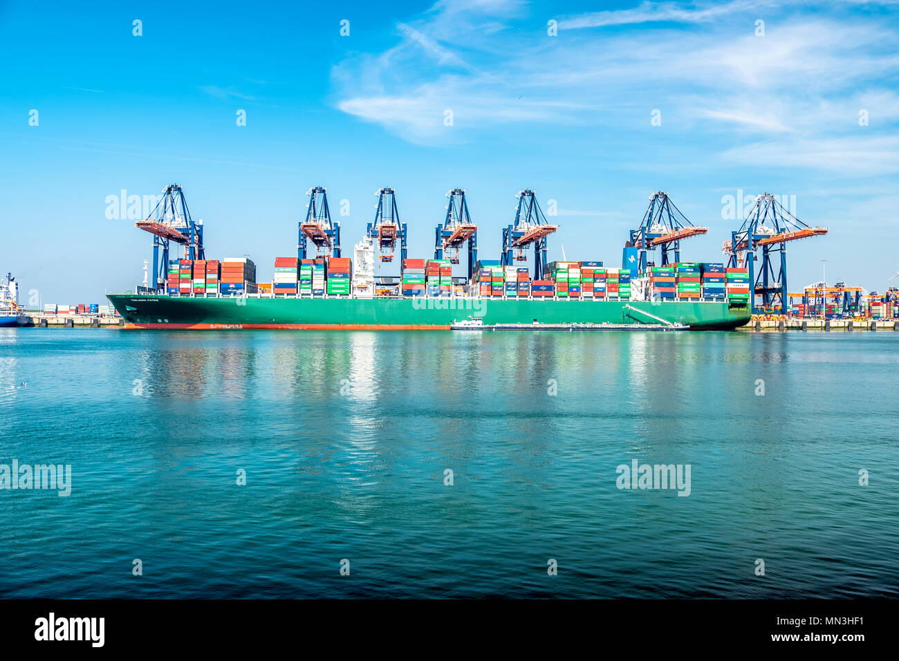 ROTTERDAM / NETHERLANDS - APRIL 20 2018 : Large harbor cranes loading ...