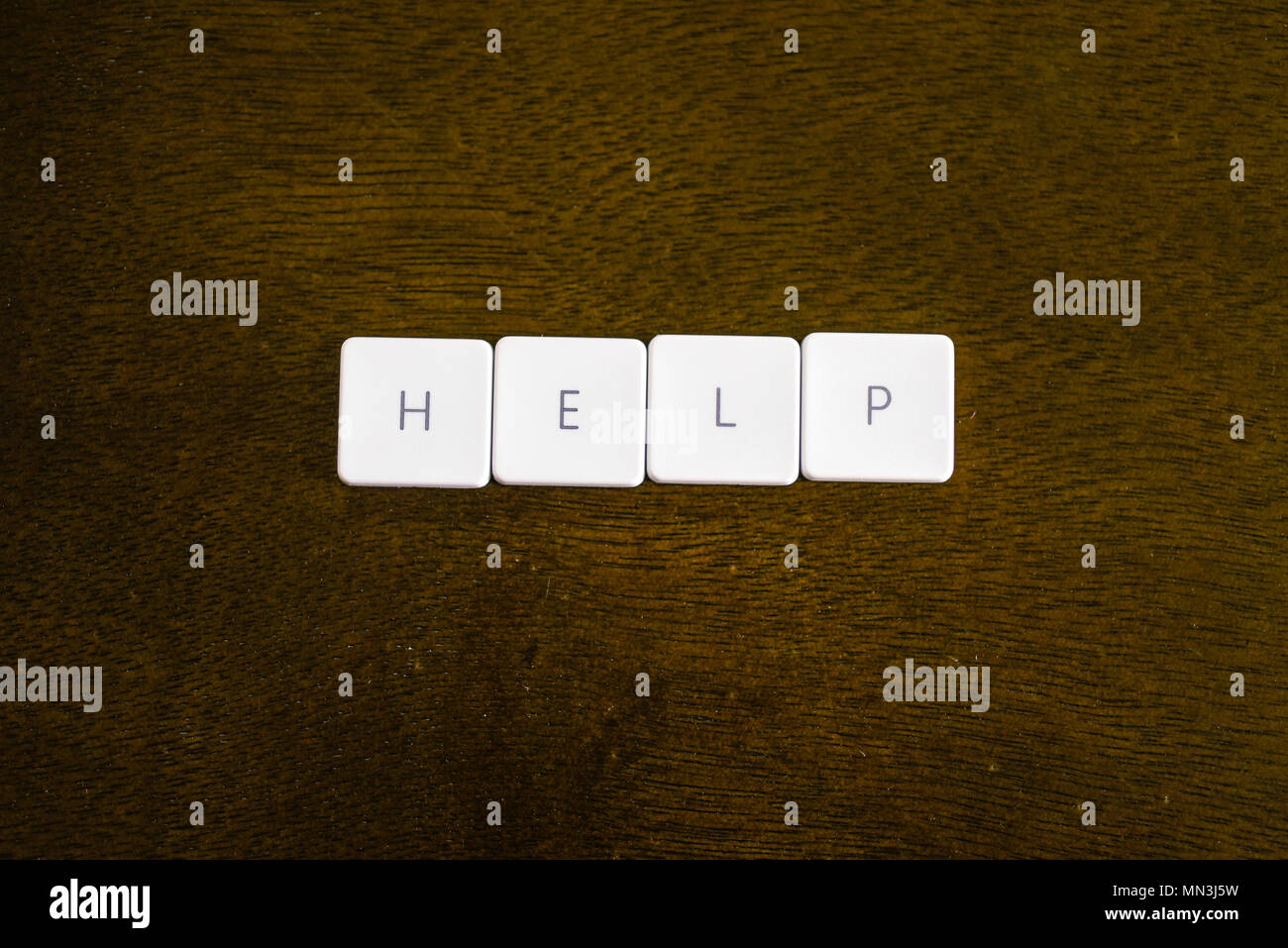 HELP word written on plastic keyboard alphabet with dark background ...