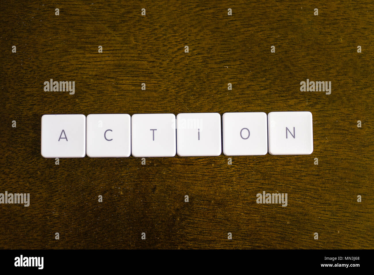 ACTION word written on plastic keyboard alphabet with dark background ...