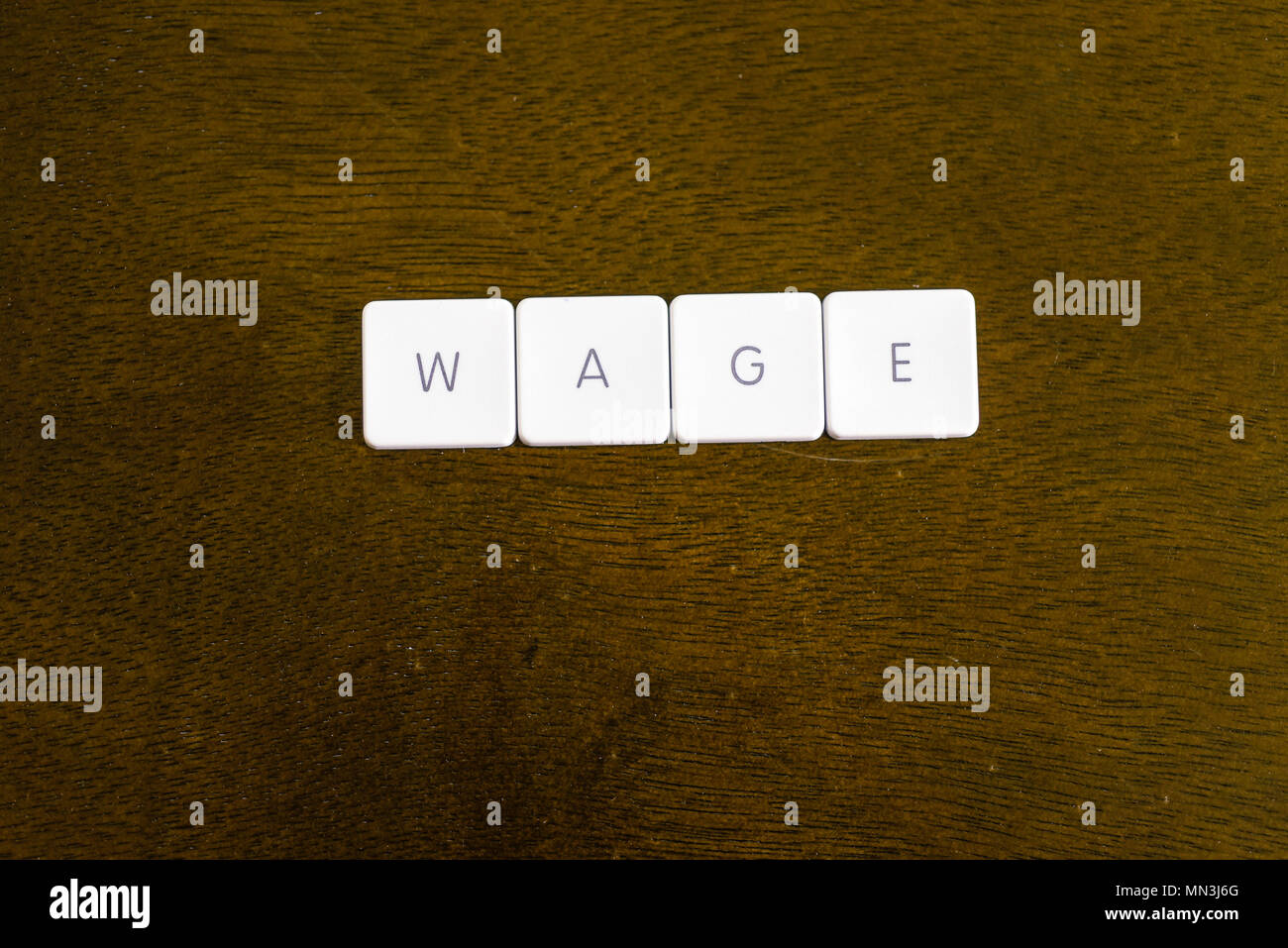 WAGE word written on plastic keyboard alphabet with dark background ...