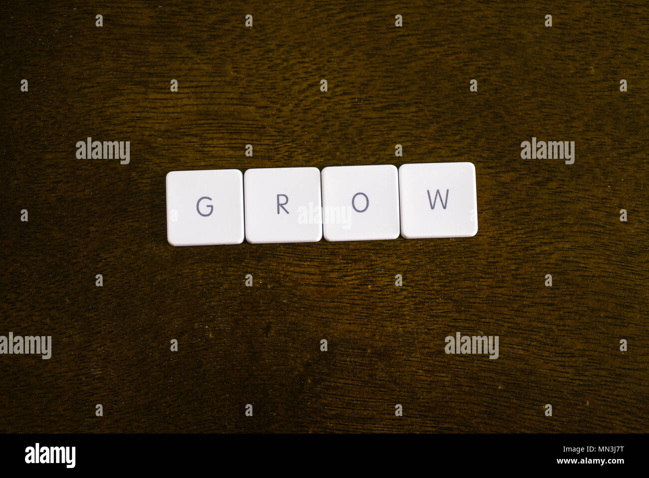 GROW word written on plastic keyboard alphabet with dark background ...