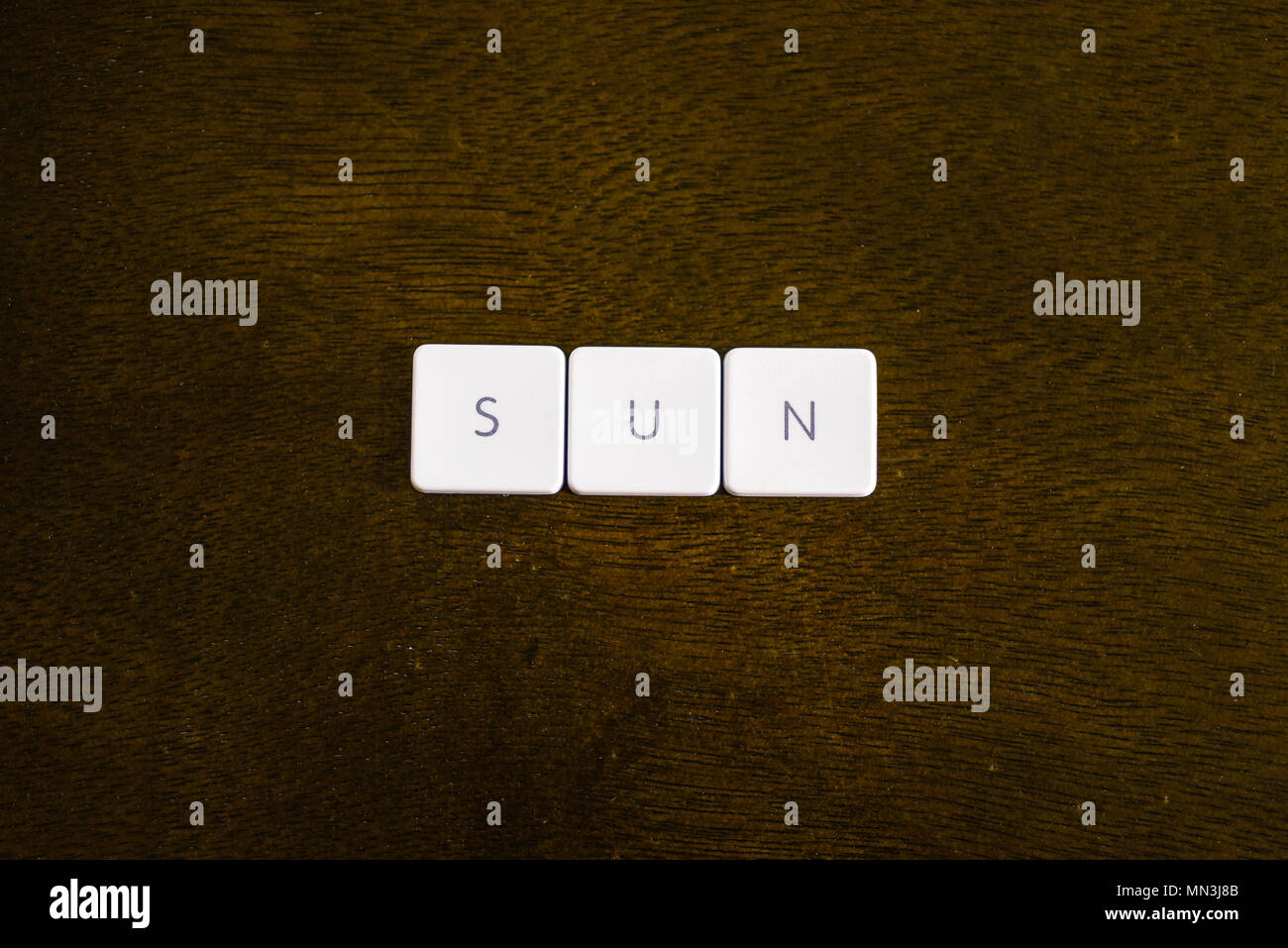 SUN word written on plastic keyboard alphabet with dark background ...