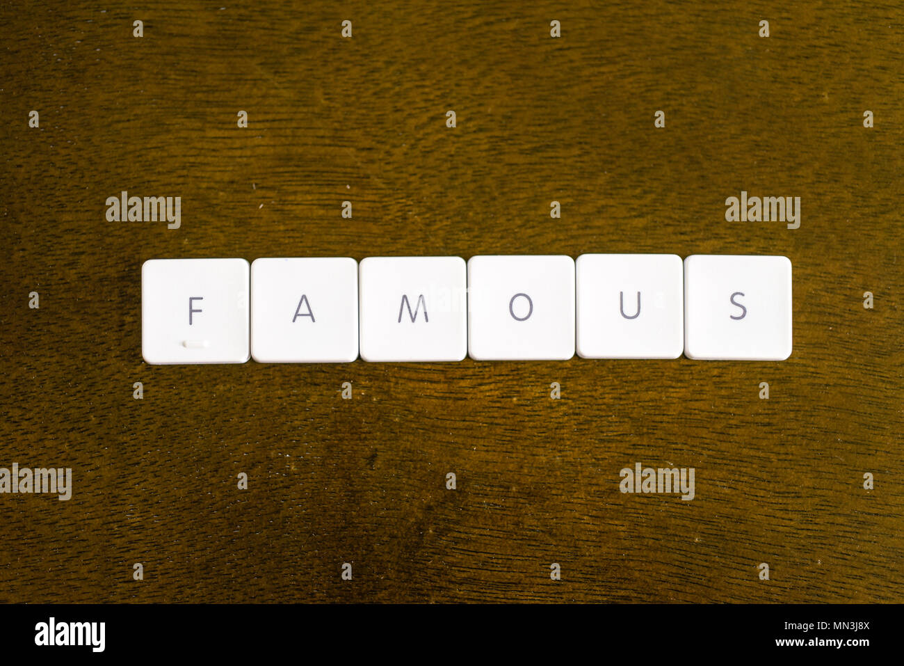 FAMOUSword written on plastic keyboard alphabet with dark background ...