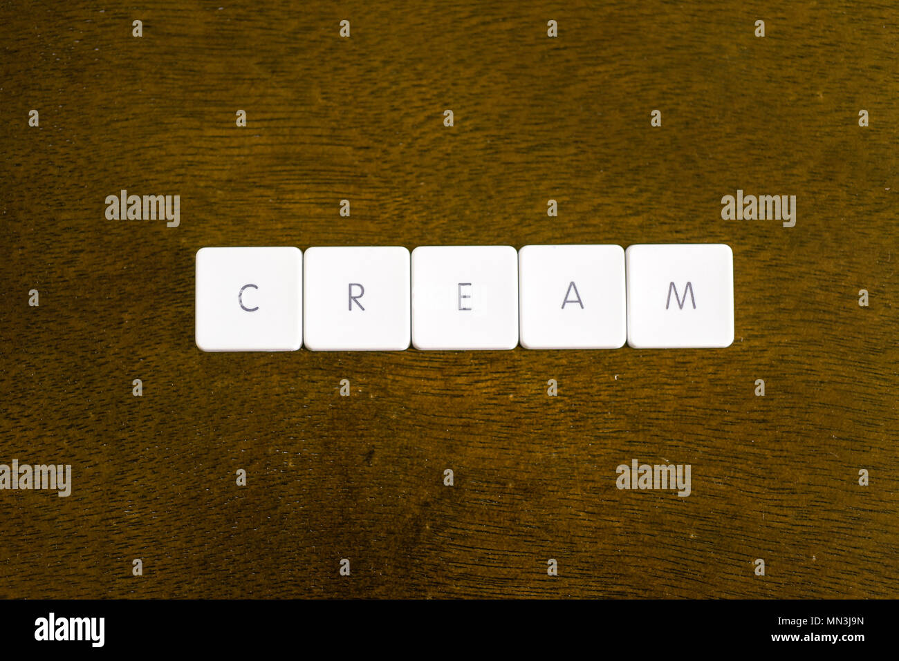 CREAM word written on plastic keyboard alphabet with dark background ...