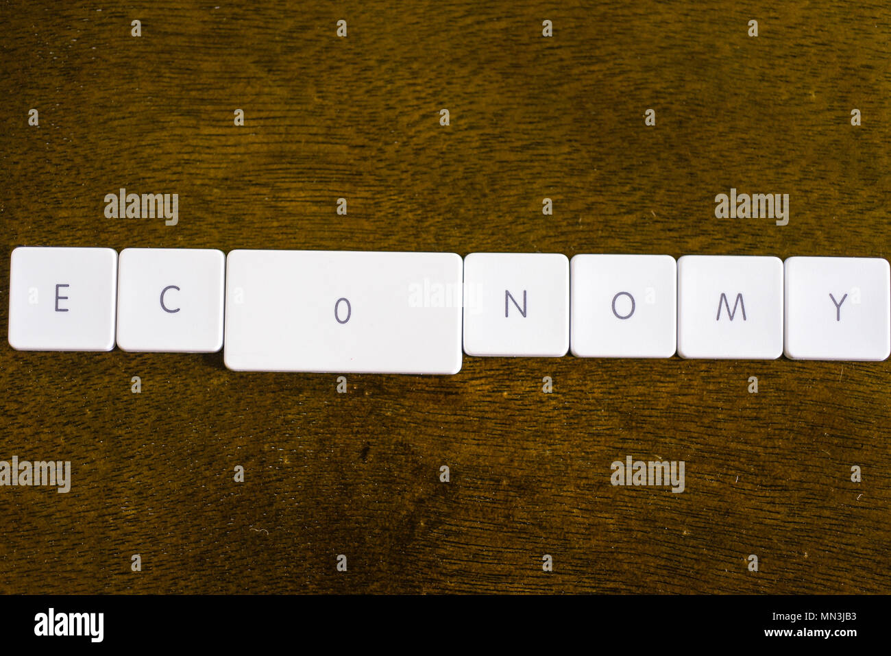 ECONOMY word written on plastic keyboard alphabet with dark background ...
