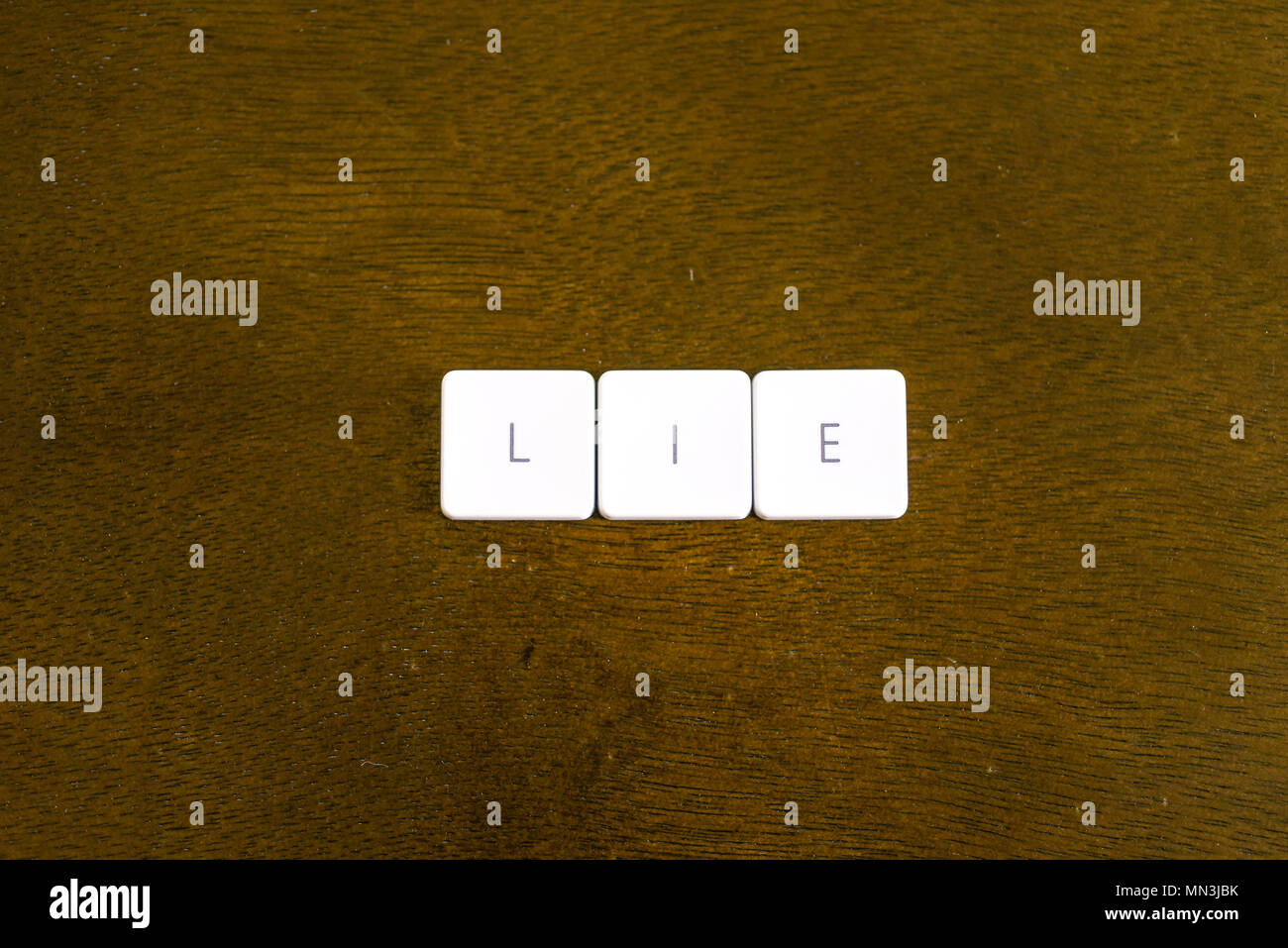 LIE word written on plastic keyboard alphabet with dark background ...