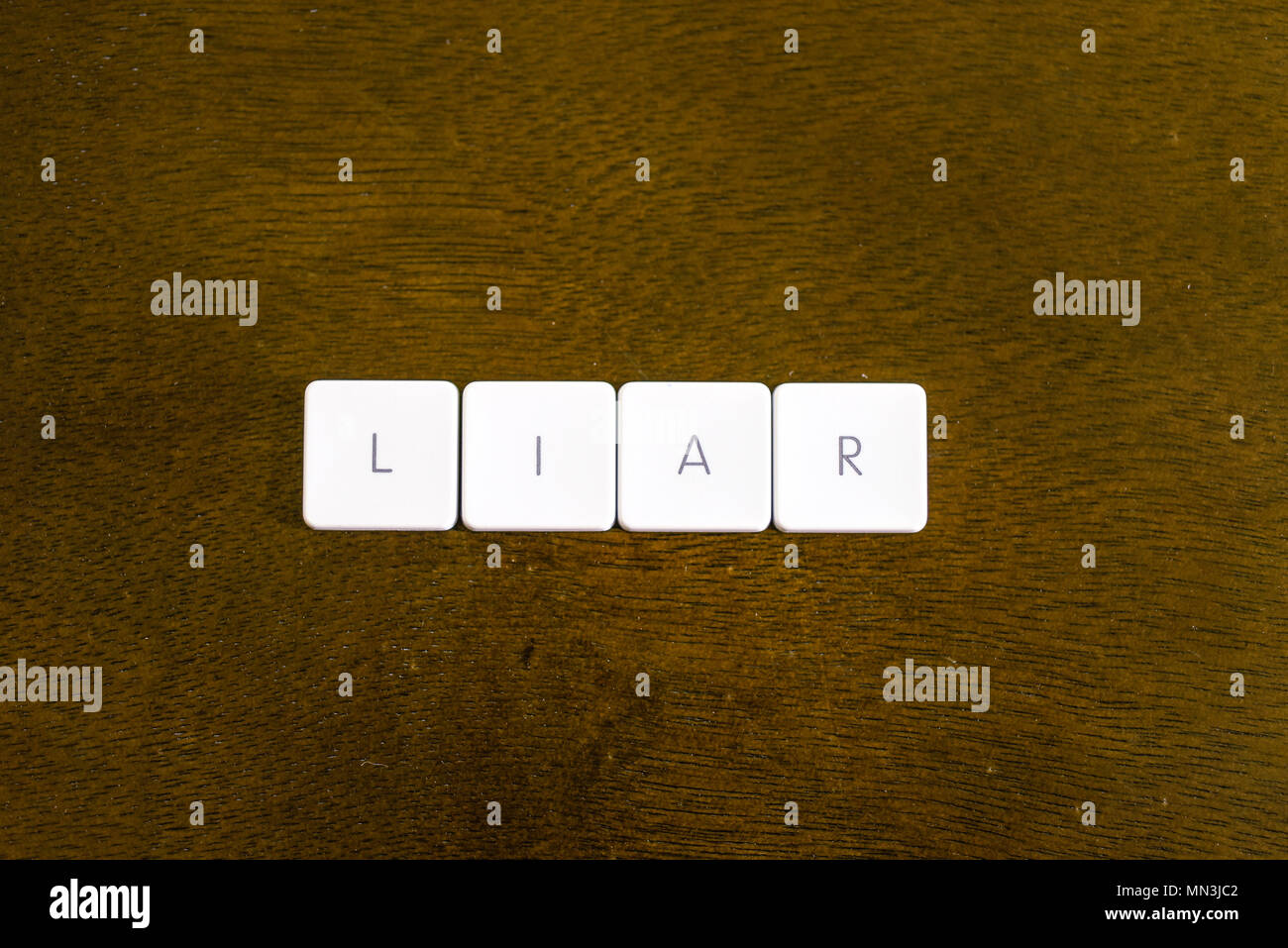LIAR word written on plastic keyboard alphabet with dark background ...