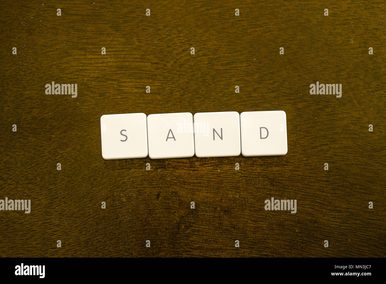 SAND word written on plastic keyboard alphabet with dark background ...