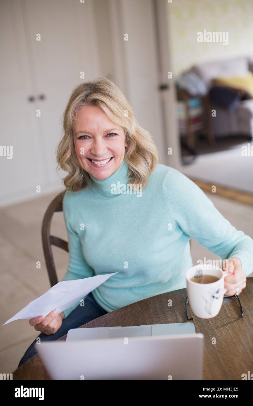 Portrait smiling, confident female freelancer working at laptop and ...