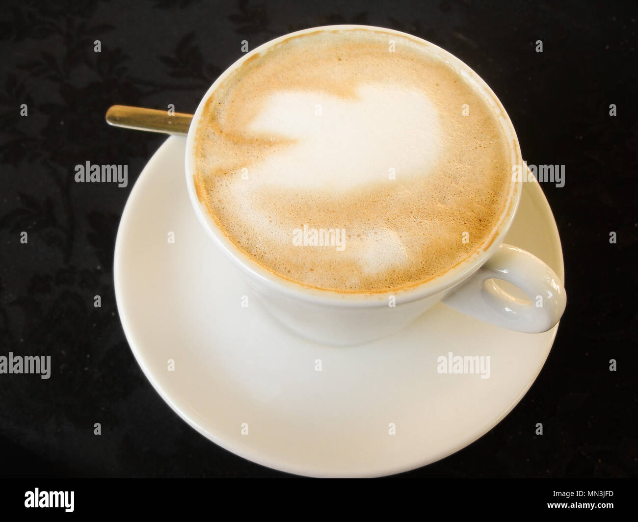 White coffee Cup with a gourmet coffee and foam figure Stock Photo - Alamy