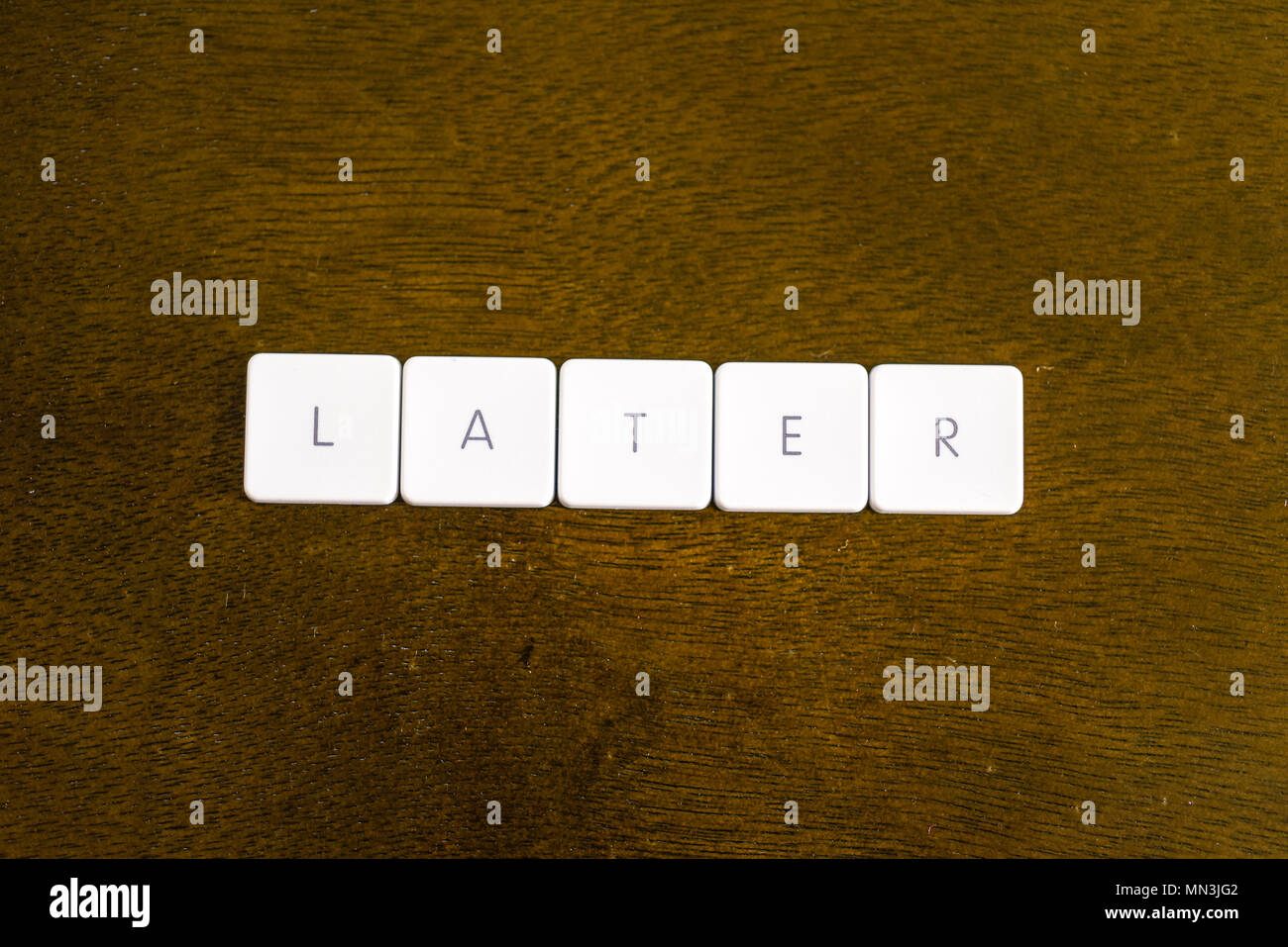 LATER word written on plastic keyboard alphabet with dark background ...