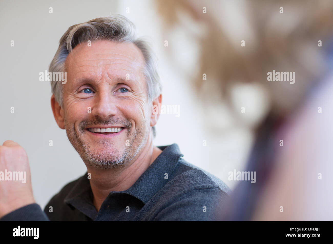 Smiling mature man listening to woman Stock Photo - Alamy