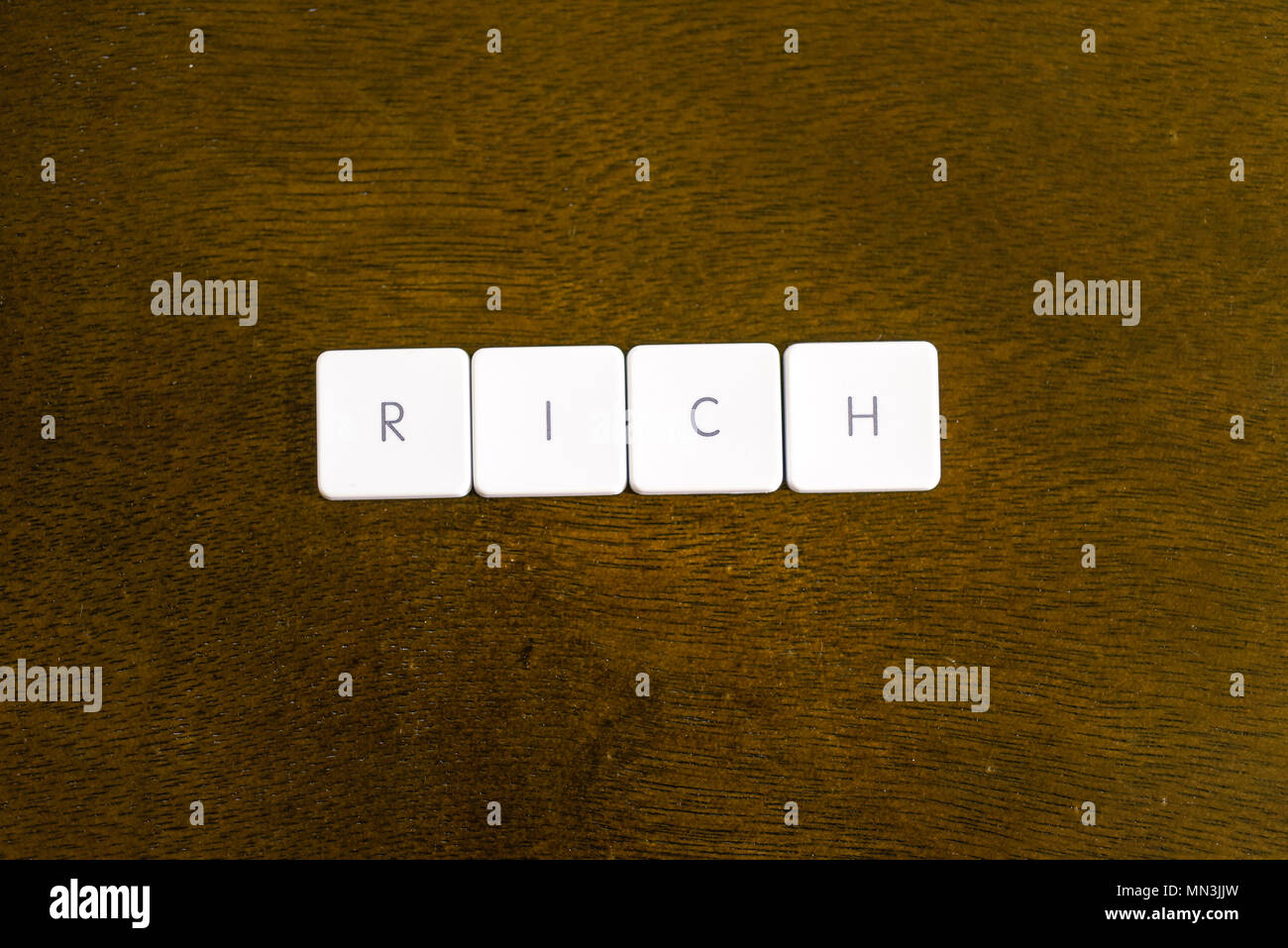 RICH word written on plastic keyboard alphabet with dark background ...