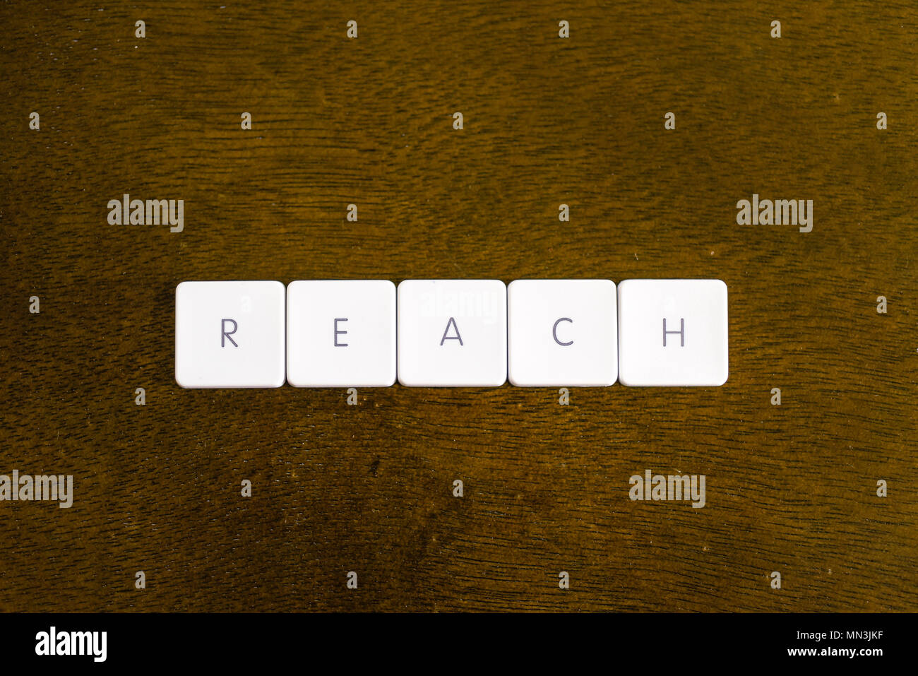 REACH word written on plastic keyboard alphabet with dark background ...