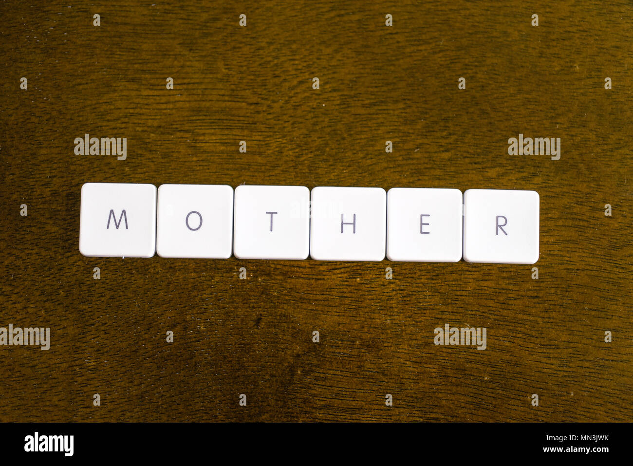 MOTHER word written on plastic keyboard alphabet with dark background ...