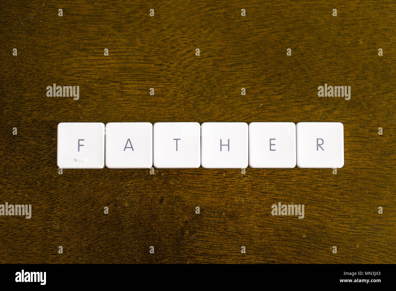 FATHER word written on plastic keyboard alphabet with dark background ...