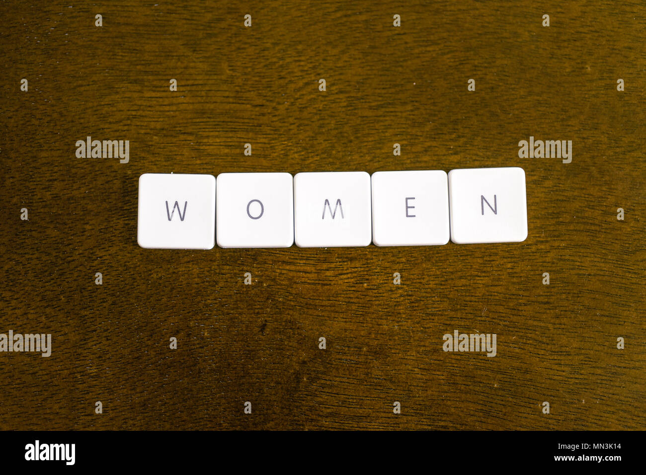 WOMEN word written on plastic keyboard alphabet with dark background ...