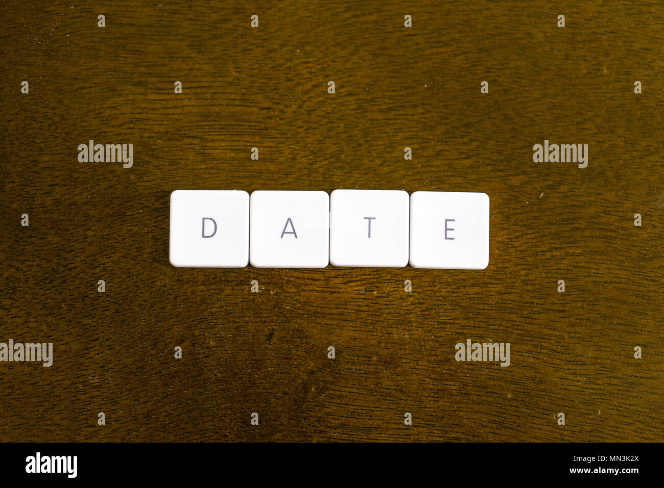 DATE word written on plastic keyboard alphabet with dark background ...