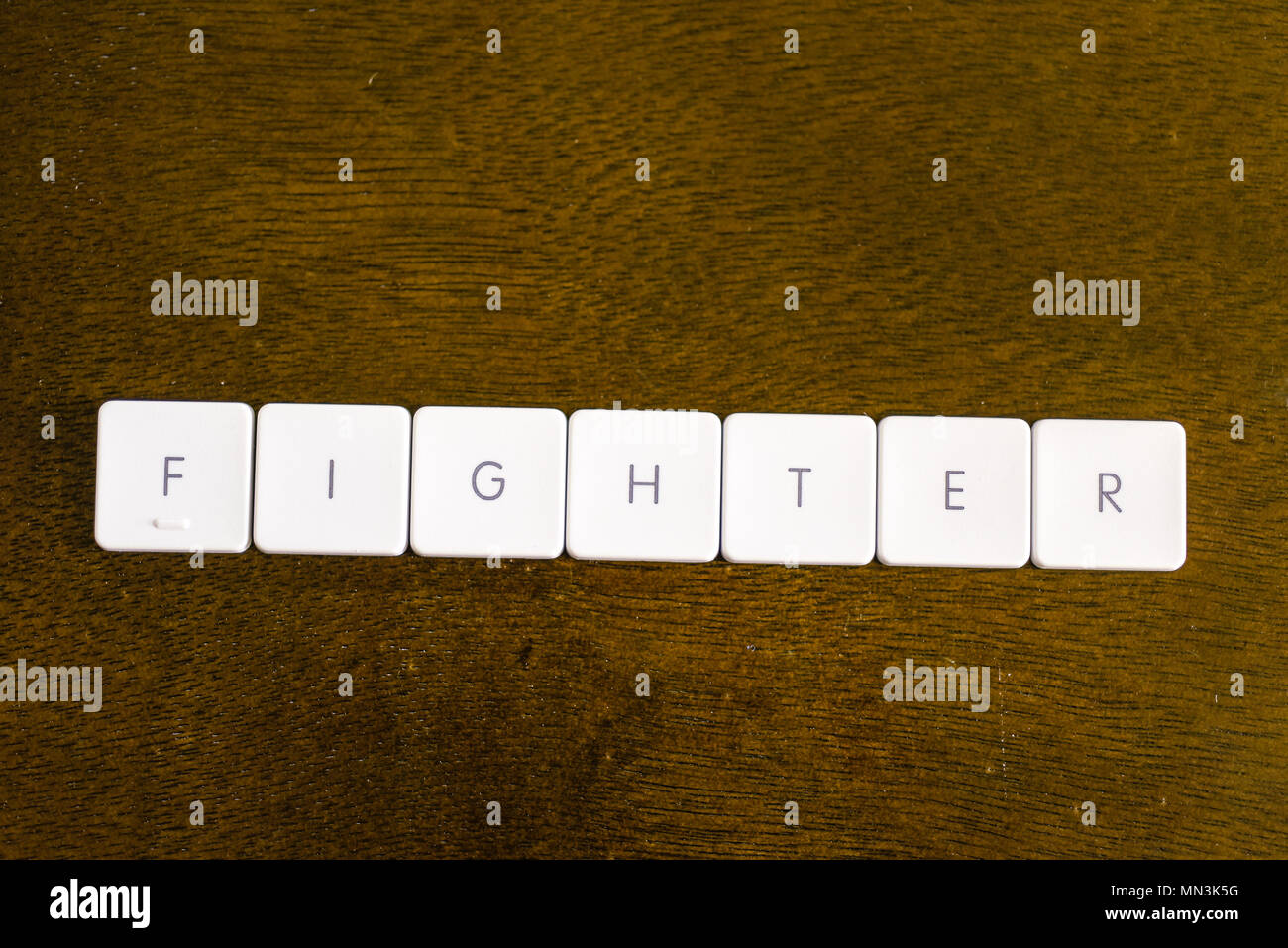 FIGHTER word written on plastic keyboard alphabet with dark background ...