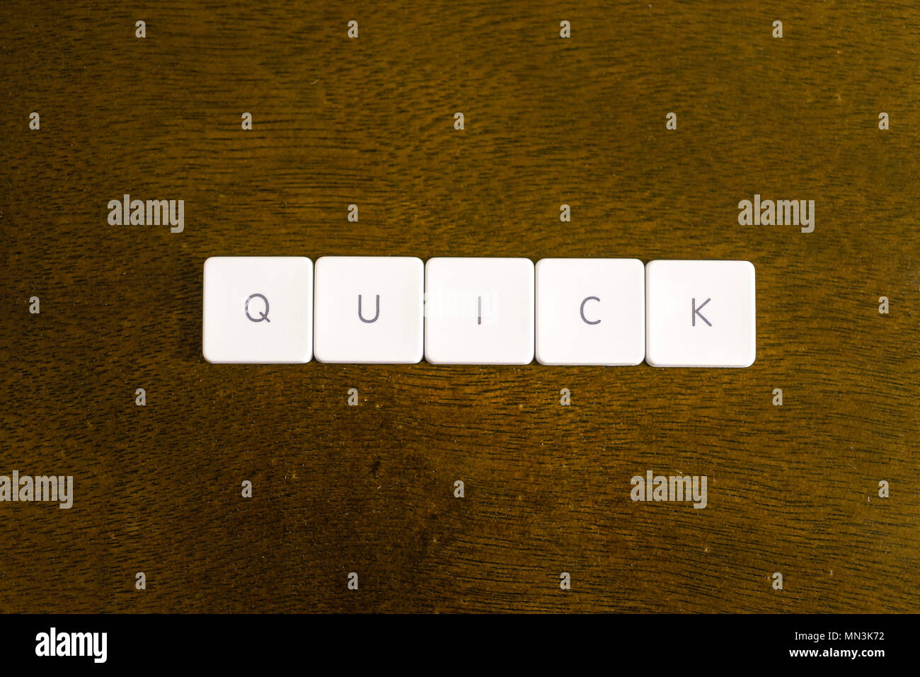 QUICK word written on plastic keyboard alphabet with dark background ...