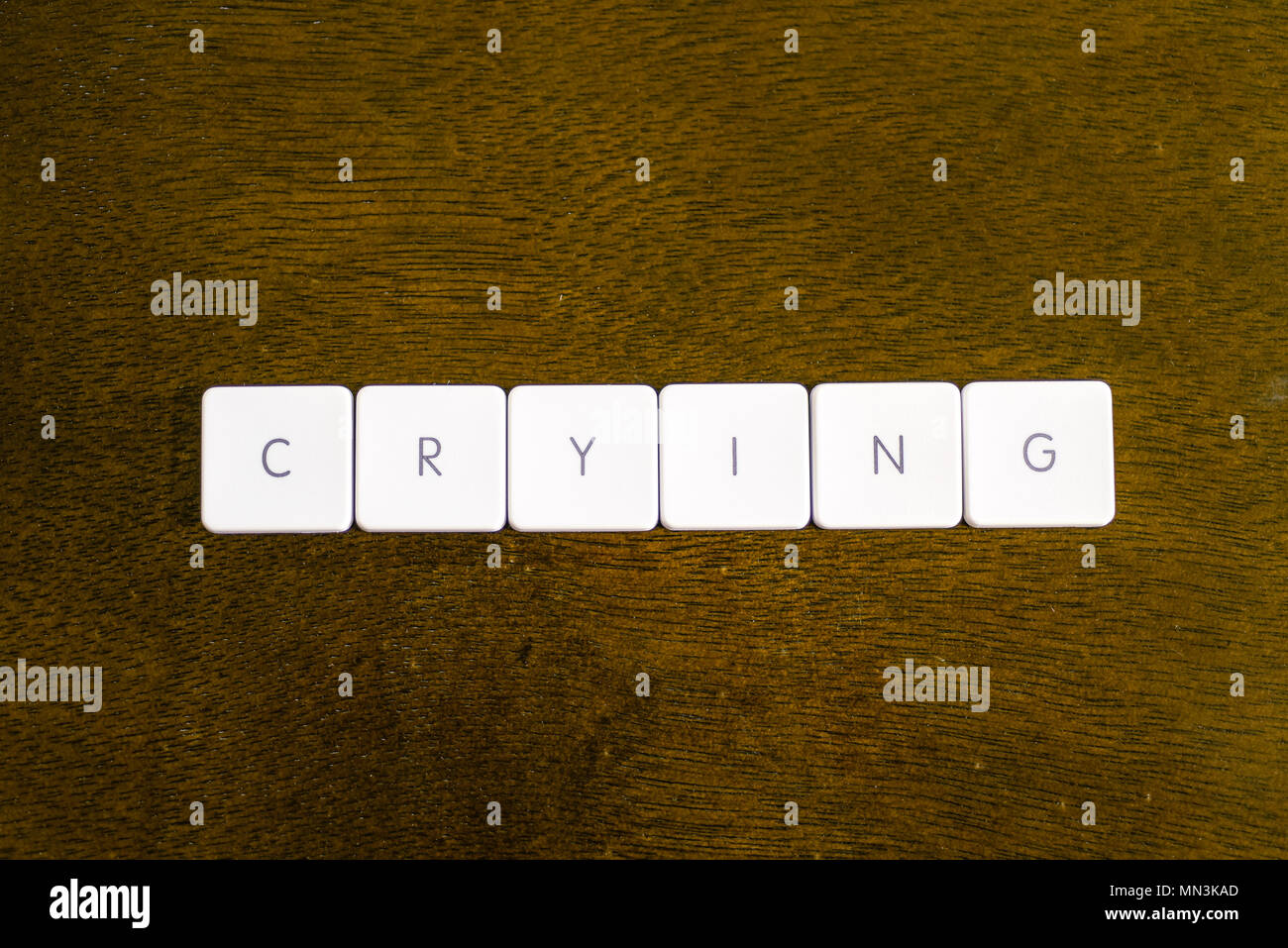CRYING word written on plastic keyboard alphabet with dark background ...