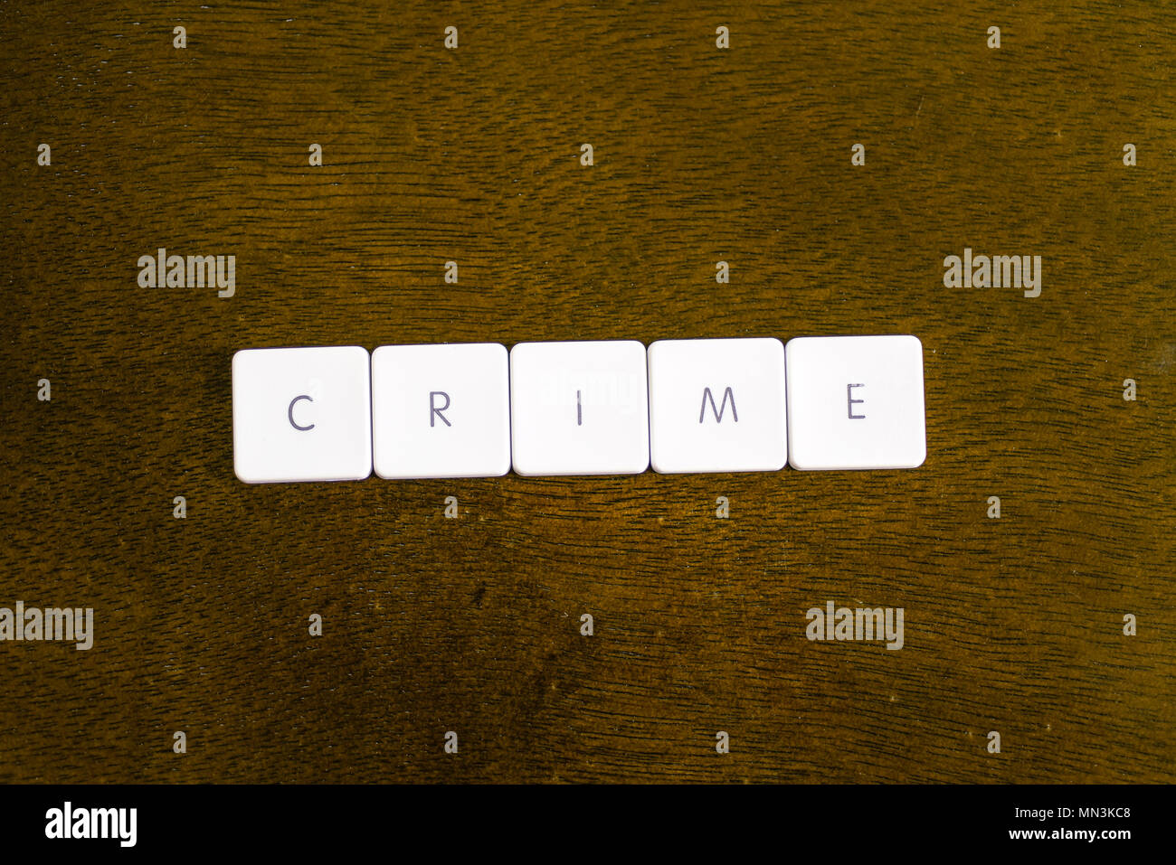 CRIME word written on plastic keyboard alphabet with dark background ...