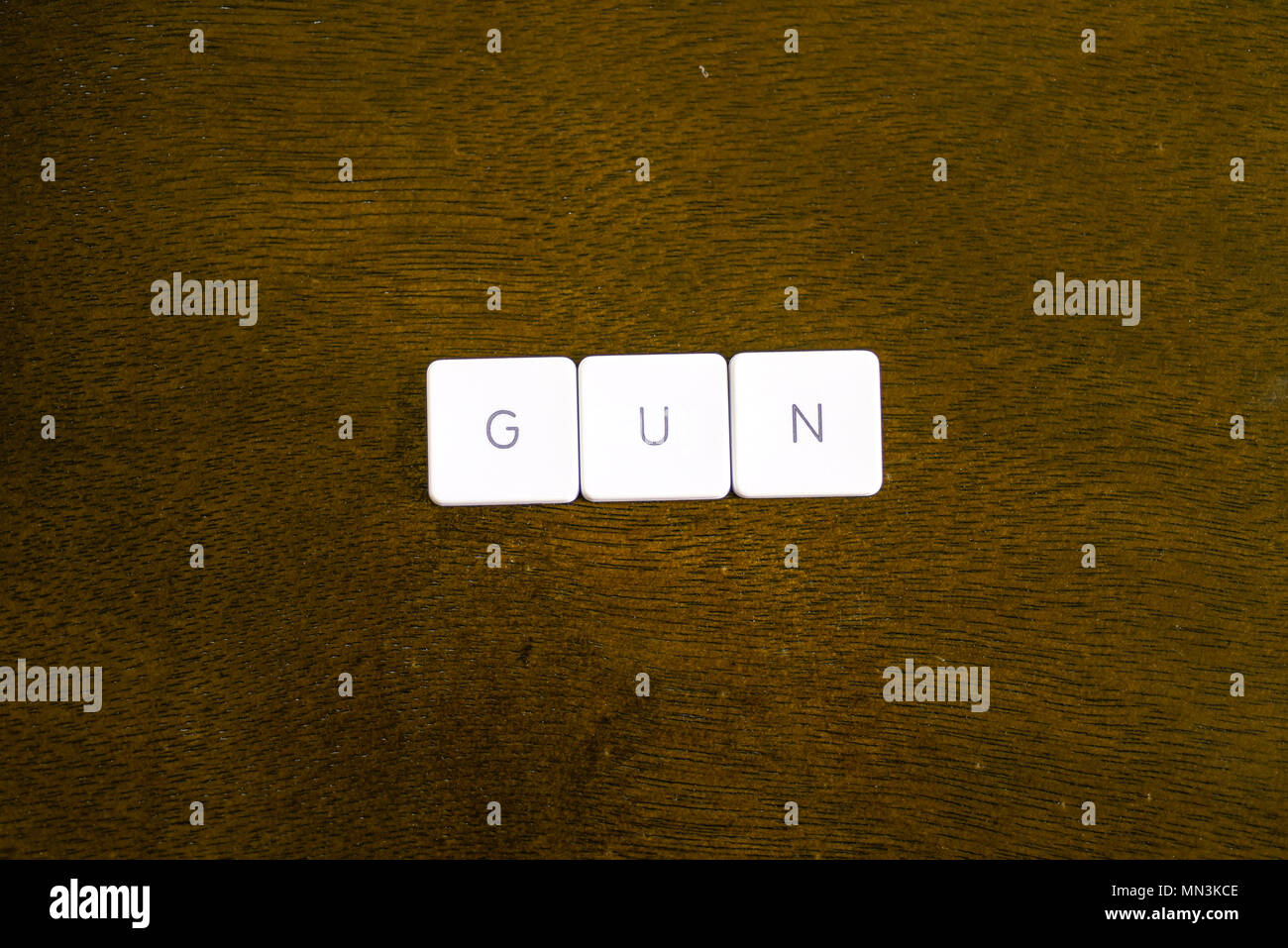 GUN word written on plastic keyboard alphabet with dark background ...