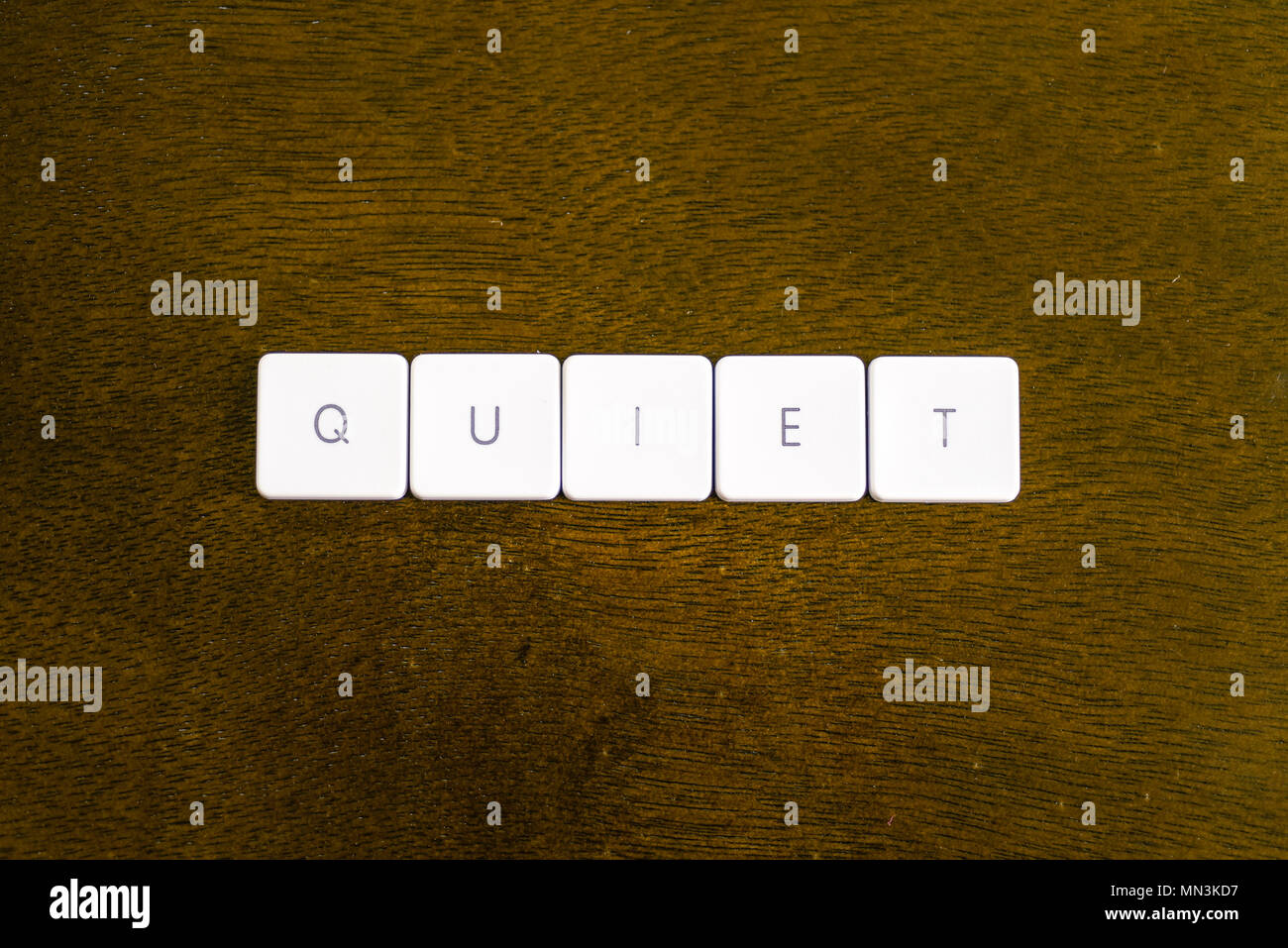 QUIET word written on plastic keyboard alphabet with dark background ...