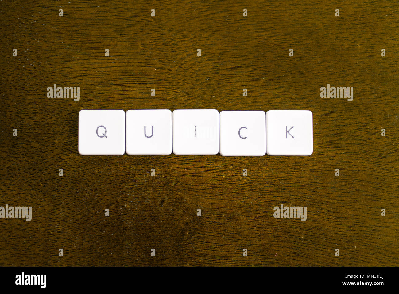 QUICK word written on plastic keyboard alphabet with dark background ...