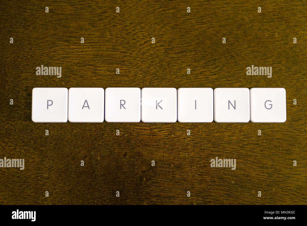 PARKING word written on plastic keyboard alphabet with dark background ...